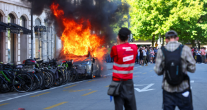 Anti-G7 Protest Erupts in Violence as Demonstrators Burn Tesla, Shatter ...